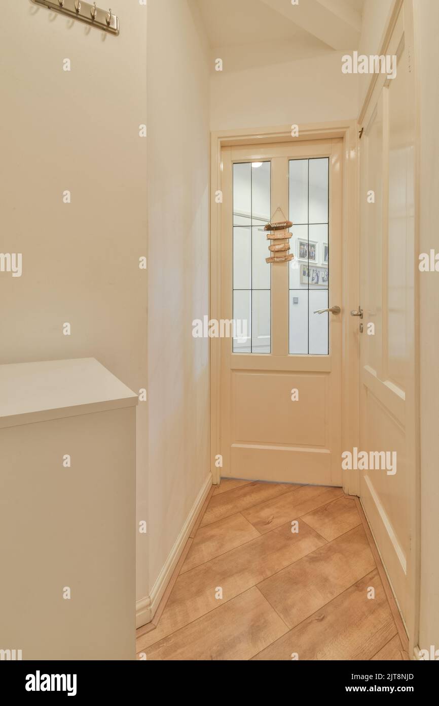 Perspective view of empty narrow hallway with white walls and wardrobe ...