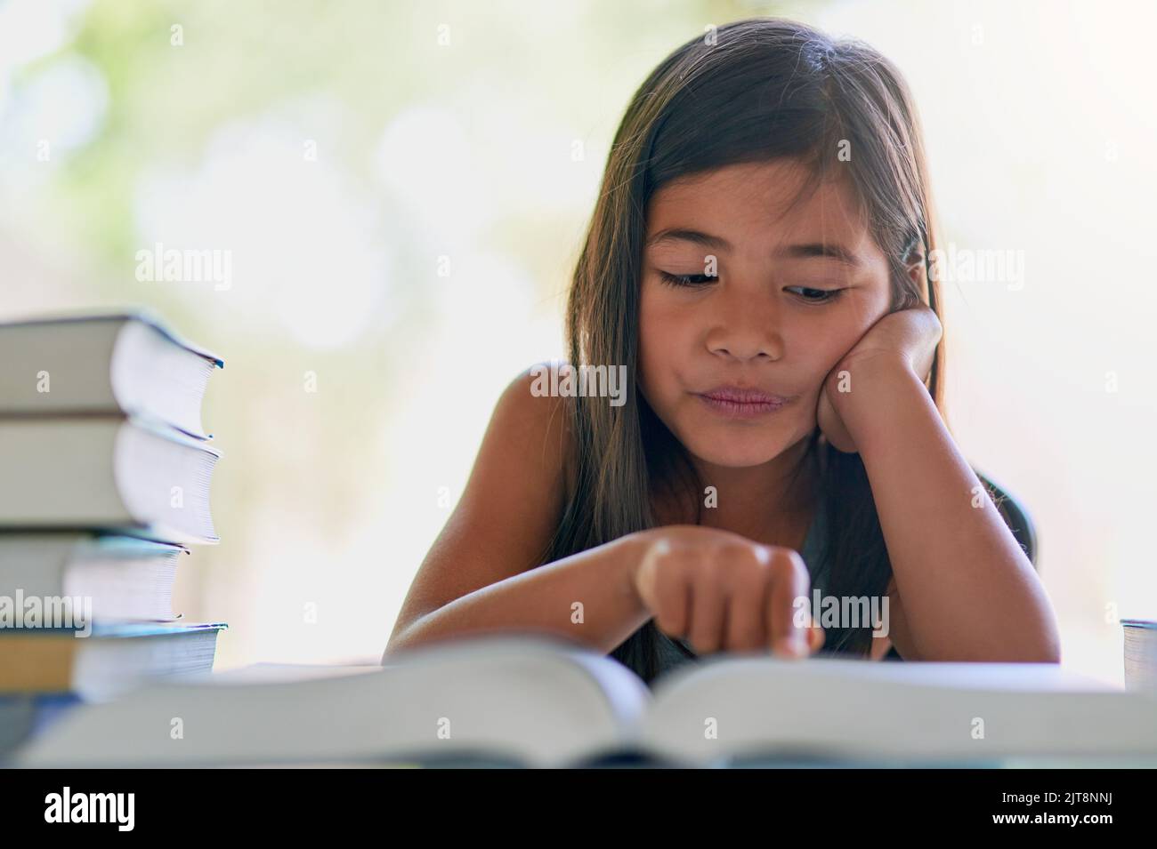 Imagination travels through reading. a little girl reading a book at ...