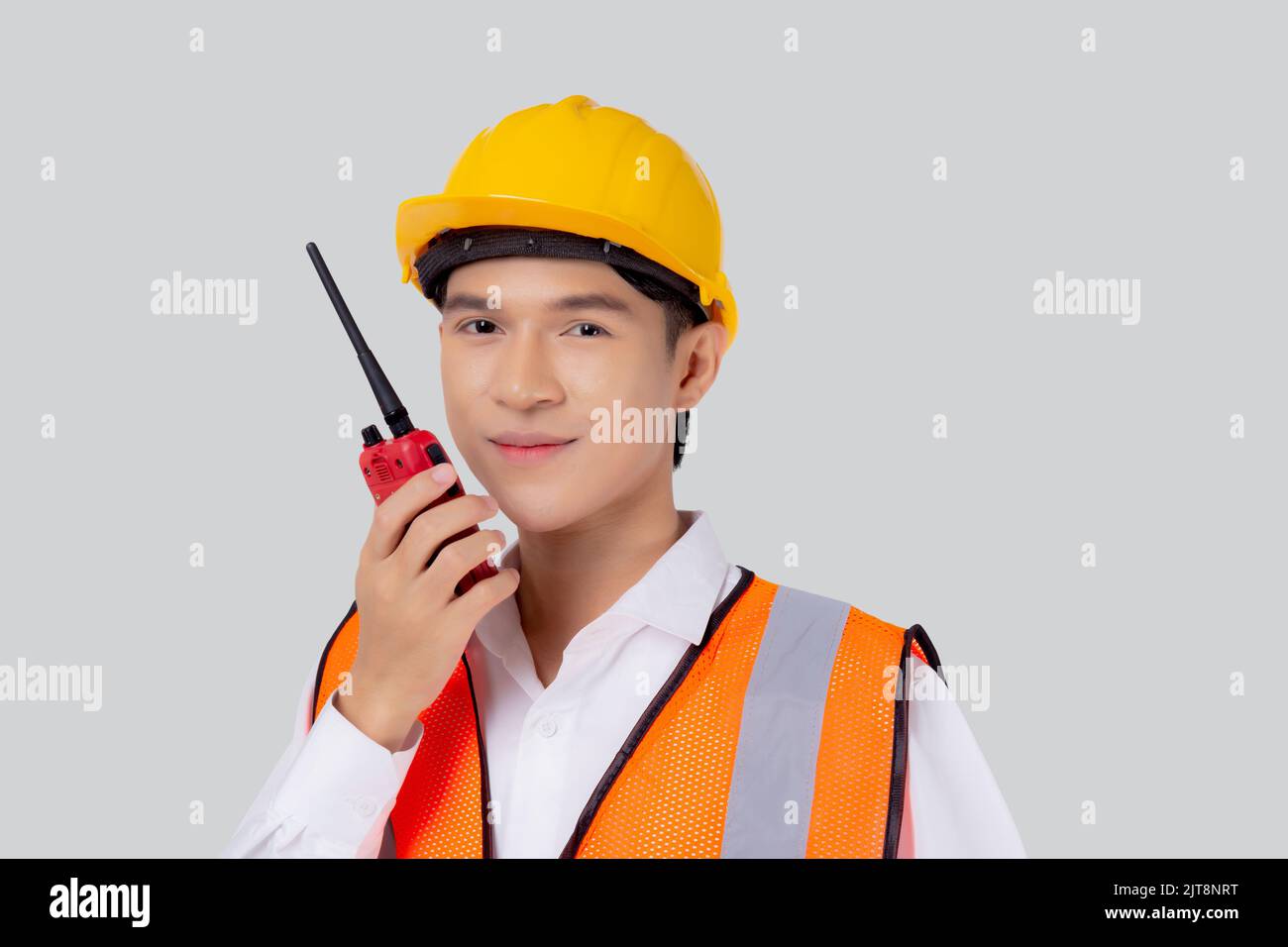 Portrait young asian man is engineer wearing helmet standing and using ...