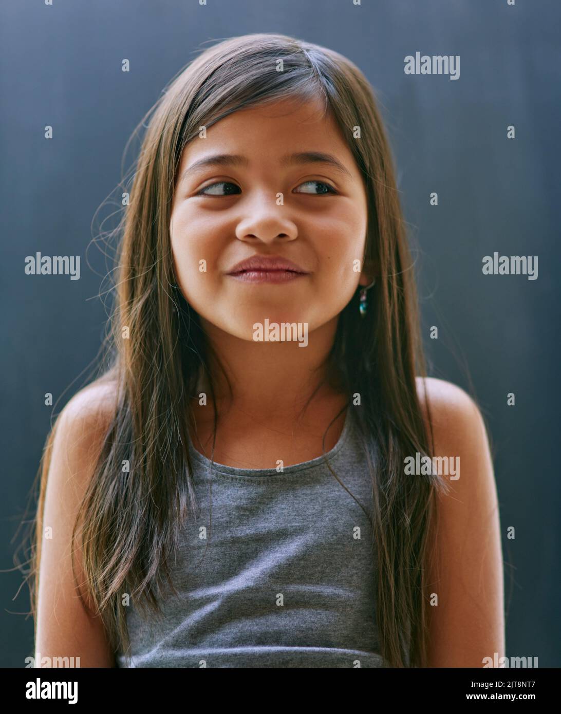 Being a kid. Studio shot of a little girl against a dark background ...