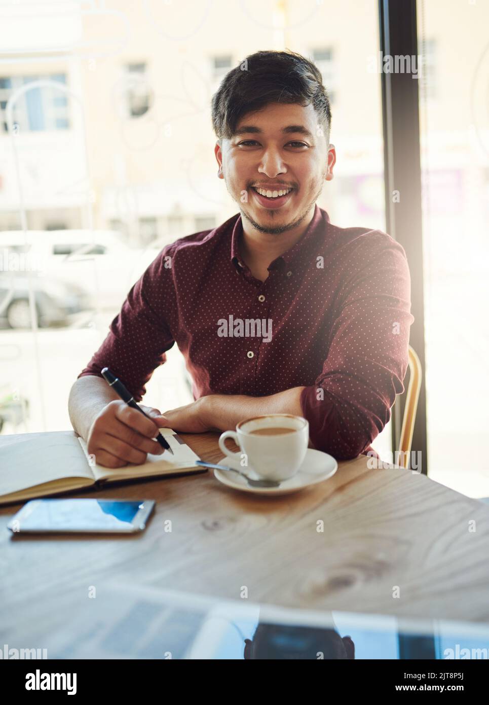 I prep for each exam. Portrait of a young student studying in a cafe ...