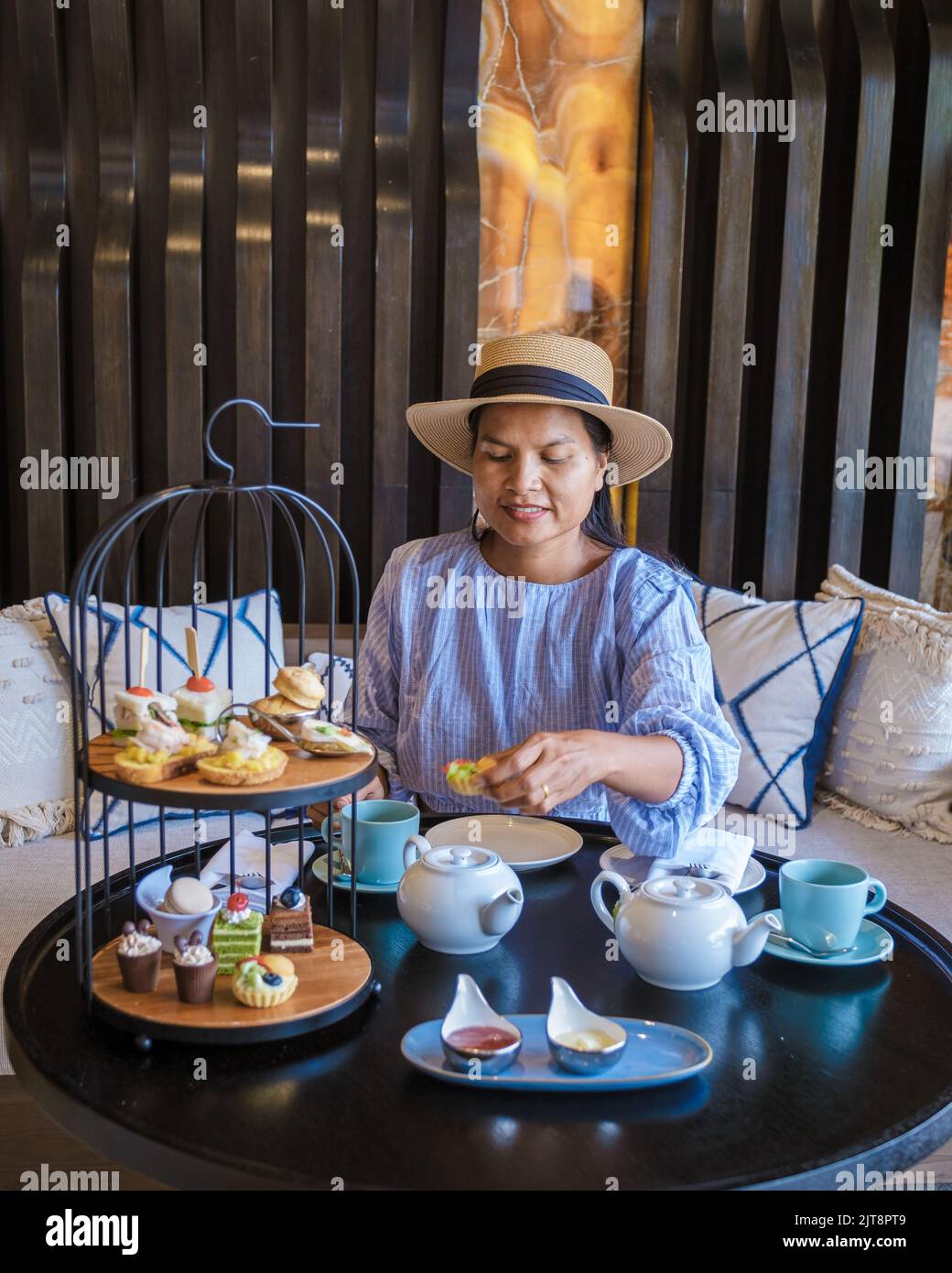 Asian women having a Luxury high tea with snacks and tea in a luxury ...