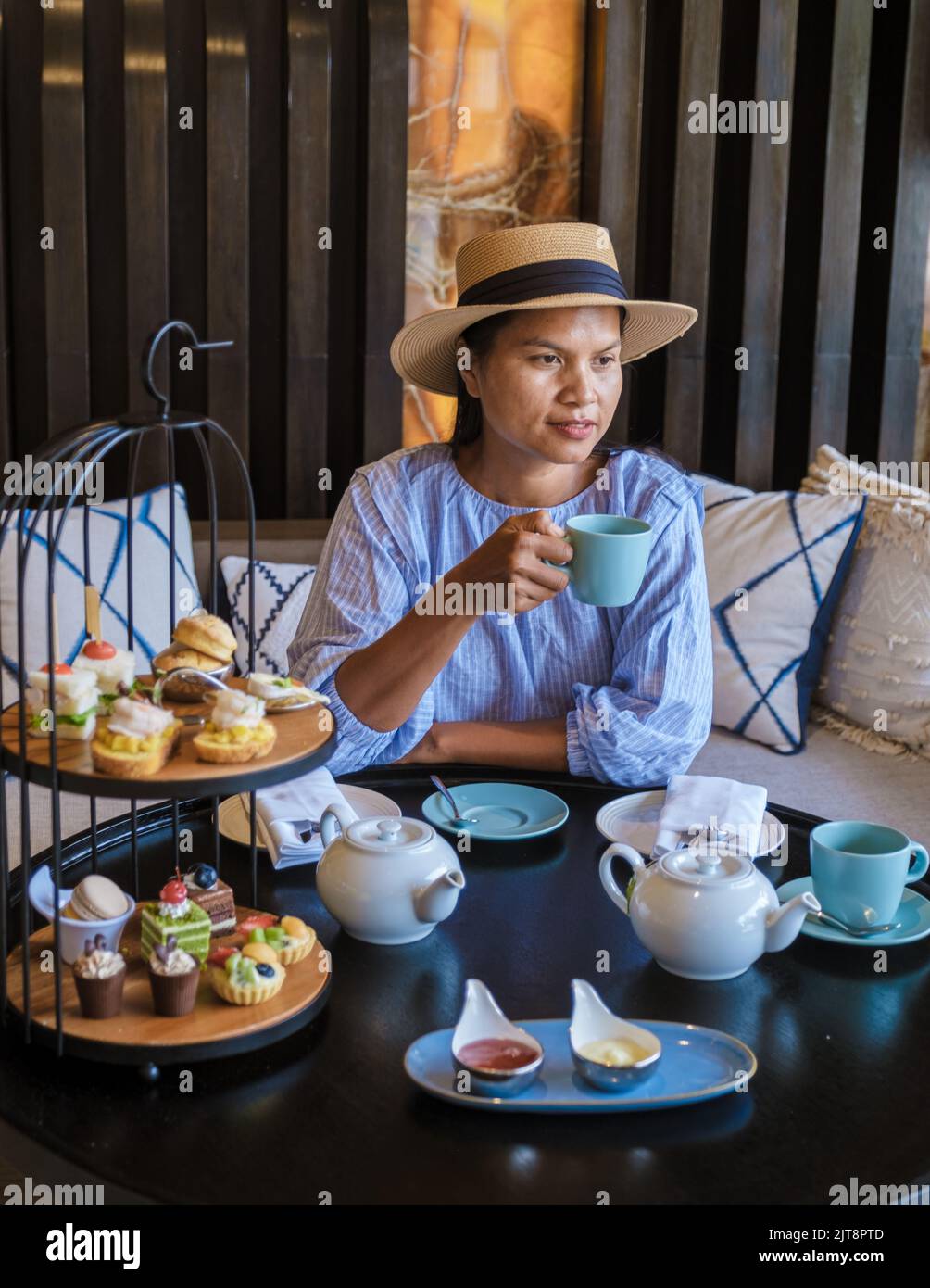 Asian women having a Luxury high tea with snacks and tea in a luxury ...