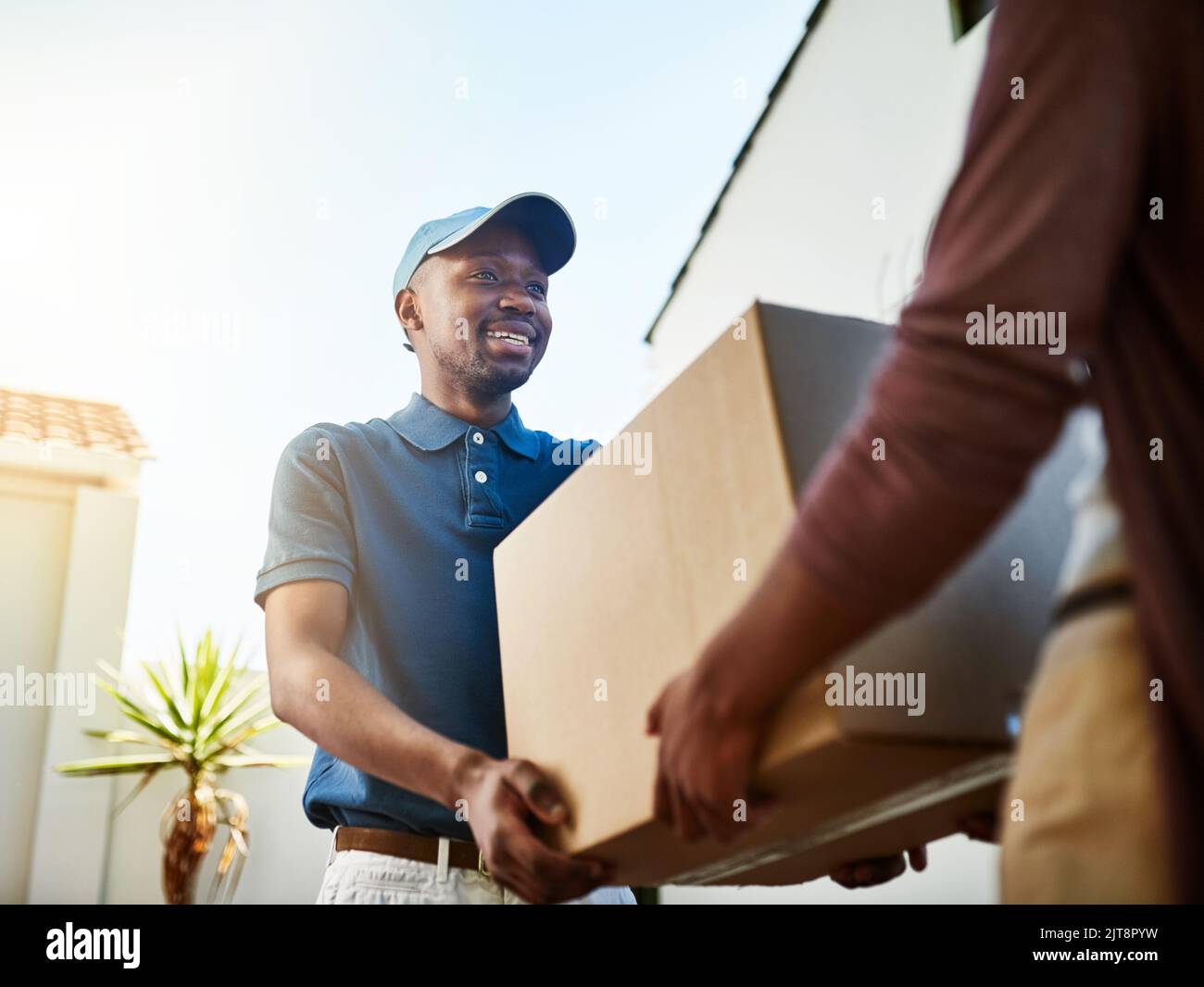 Your package has arrived. a young postal worker delivering a package to ...