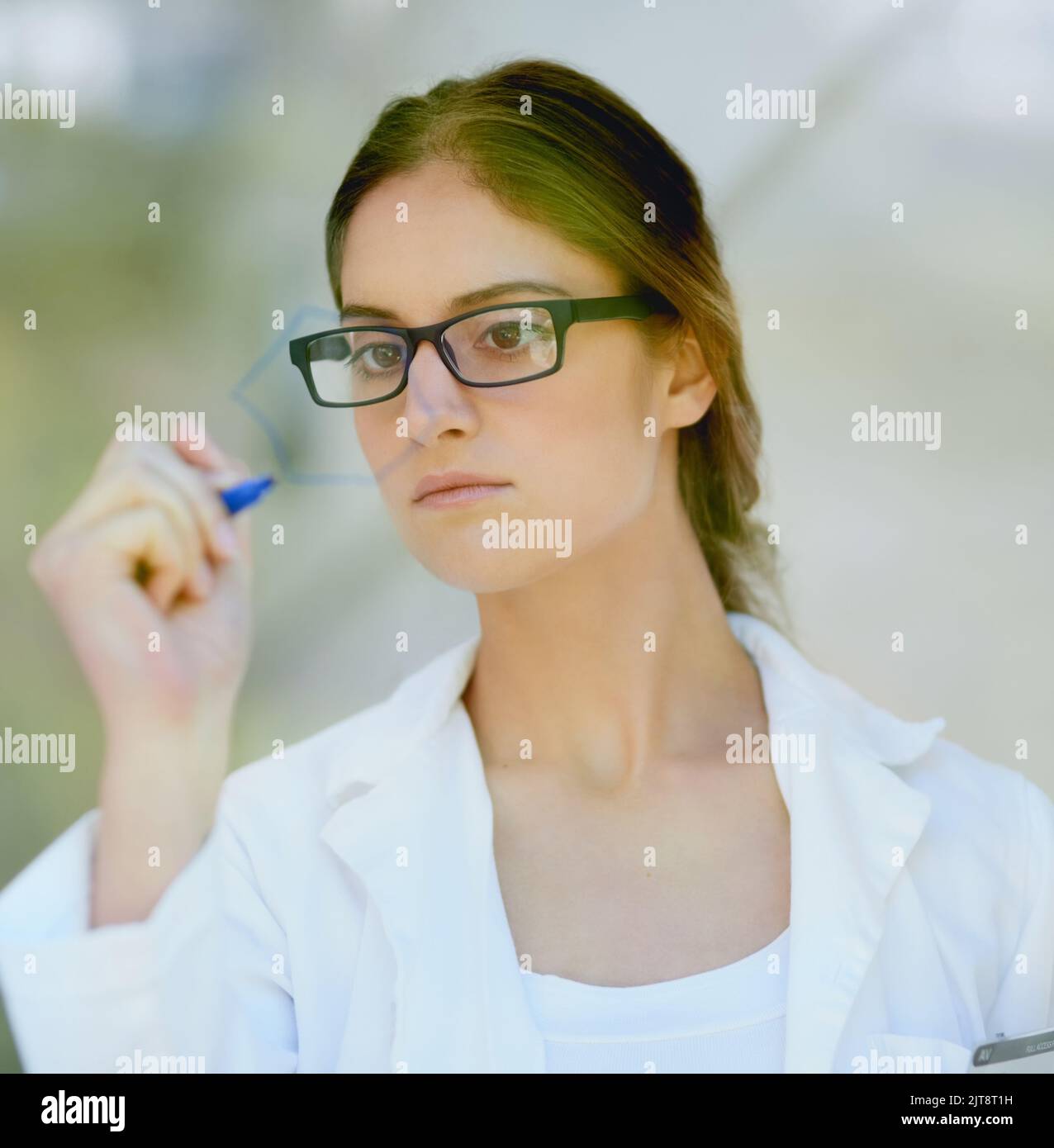 Discovery is its own reward. a scientist writing formulas on a glass ...