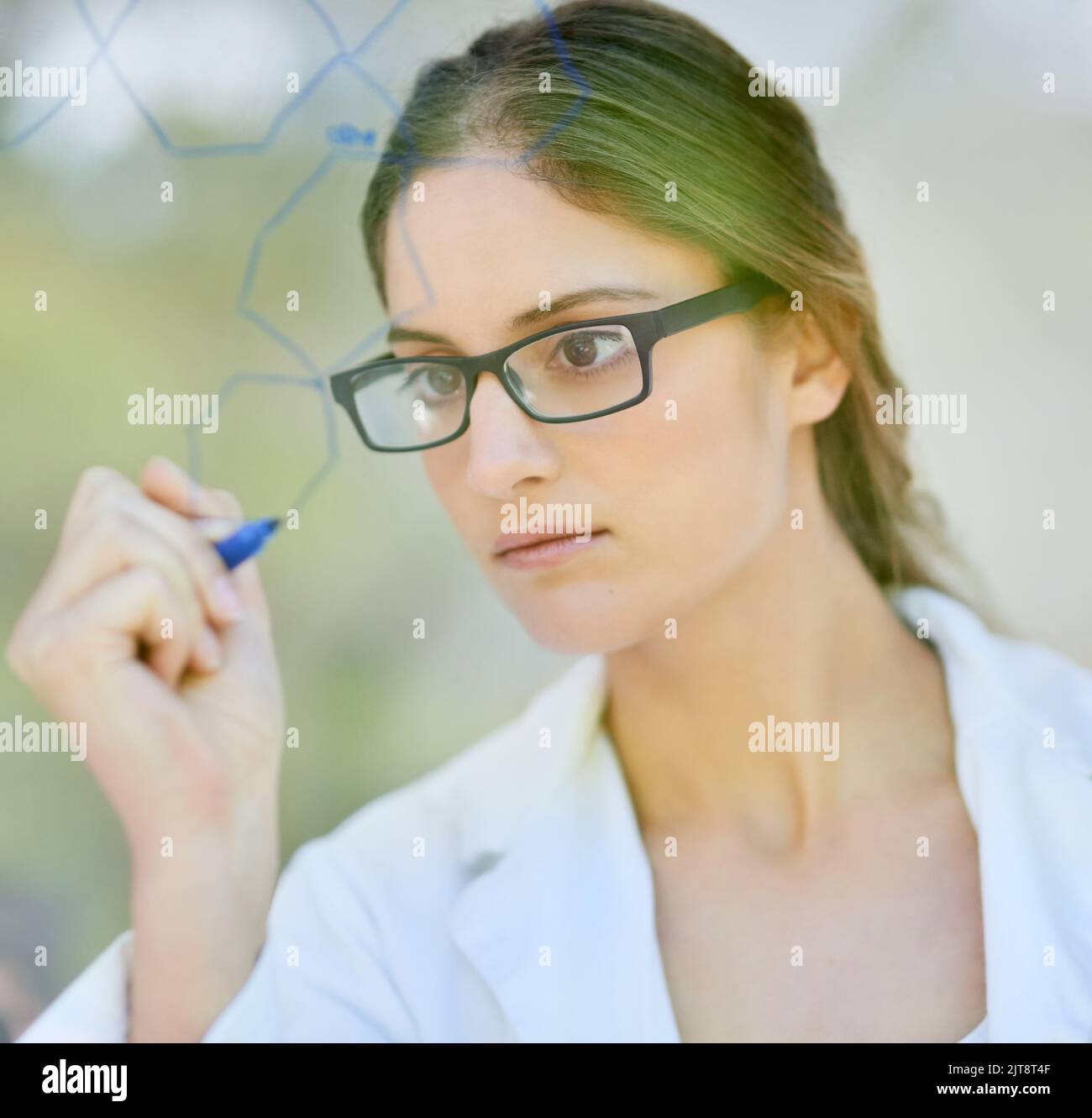 Scientific thought in action. a scientist writing formulas on a glass ...