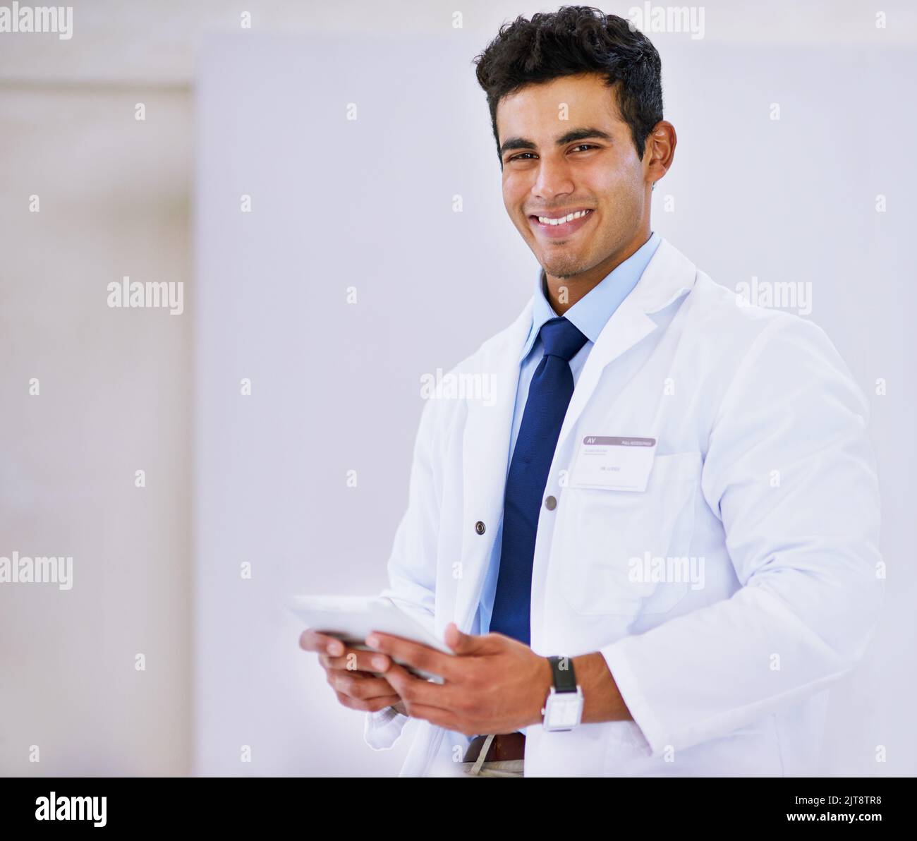 Hard at work in the lab. Portrait of a smiling lab technician using a ...