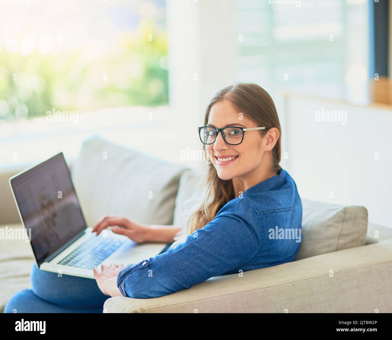 The couch is the best place to get connected. Portrait of an attractive ...