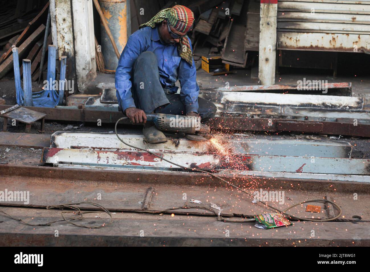 A worker without safety gear seen cutting iron plates for a ship at the ...