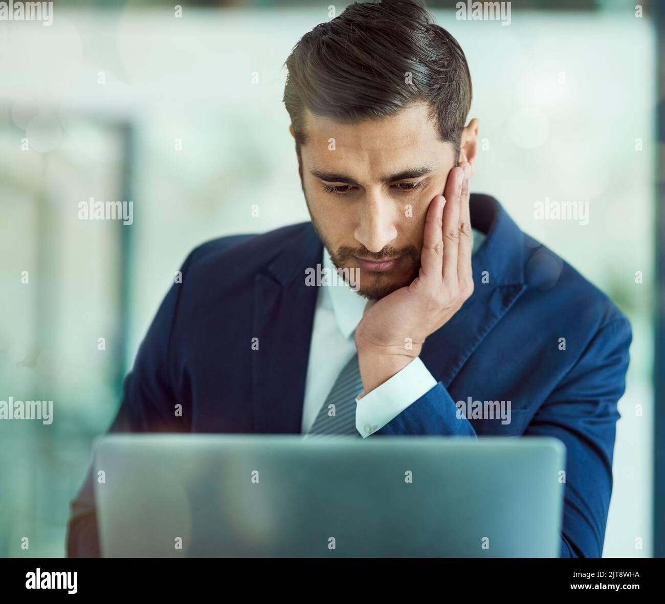 Hes a corporate problem solver. a focused executive working on a laptop ...