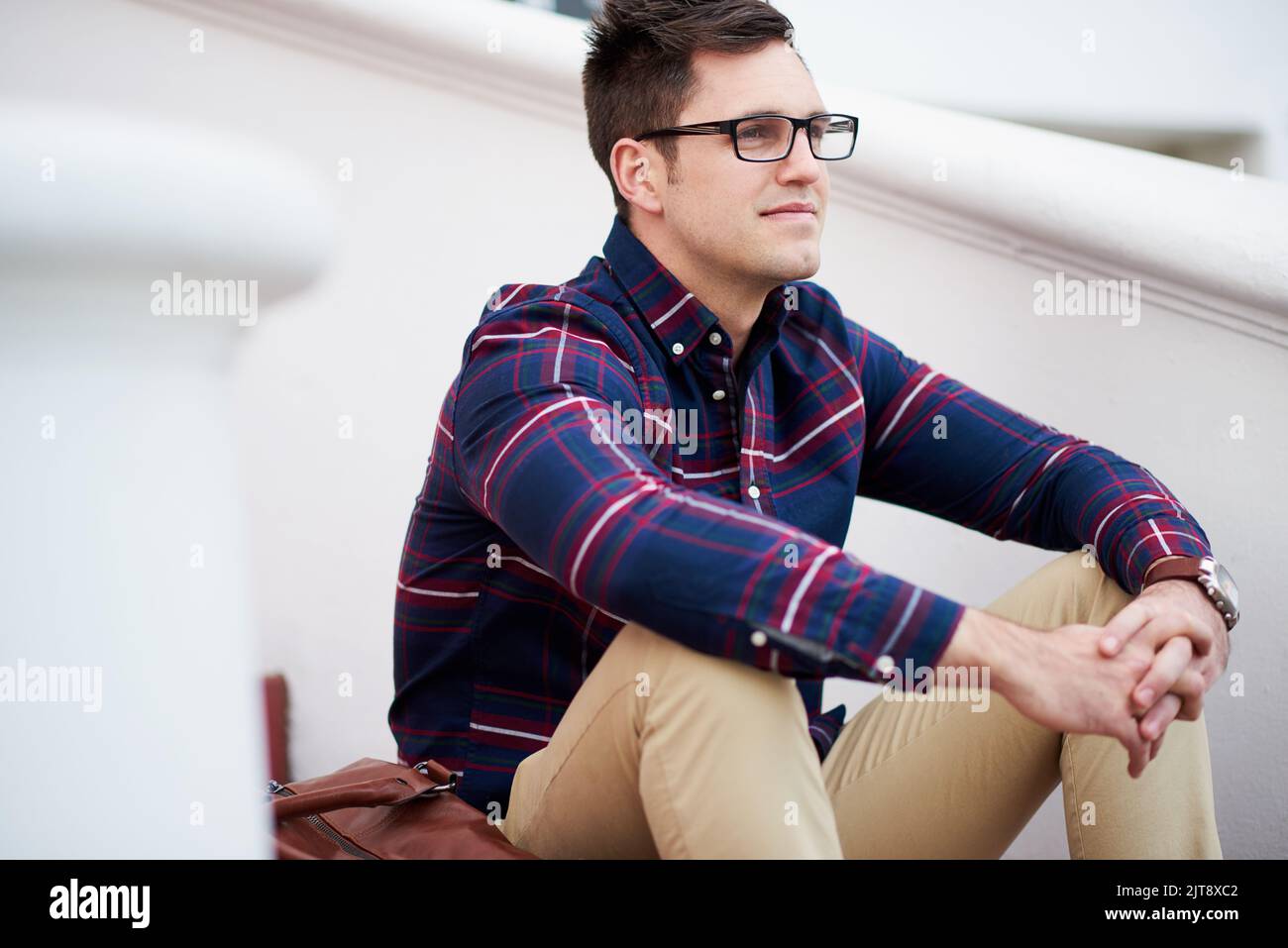 Waiting Patiently For His Friends To Arrive A Handsome Young Man Sitting On Some Steps Outside