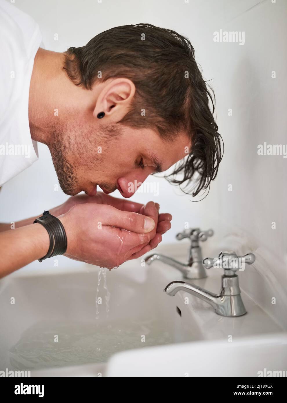 Man washing face in sink hi-res stock photography and images - Alamy