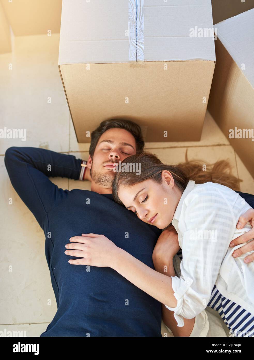 Moving house is an exhausting business. a happy young couple resting on ...