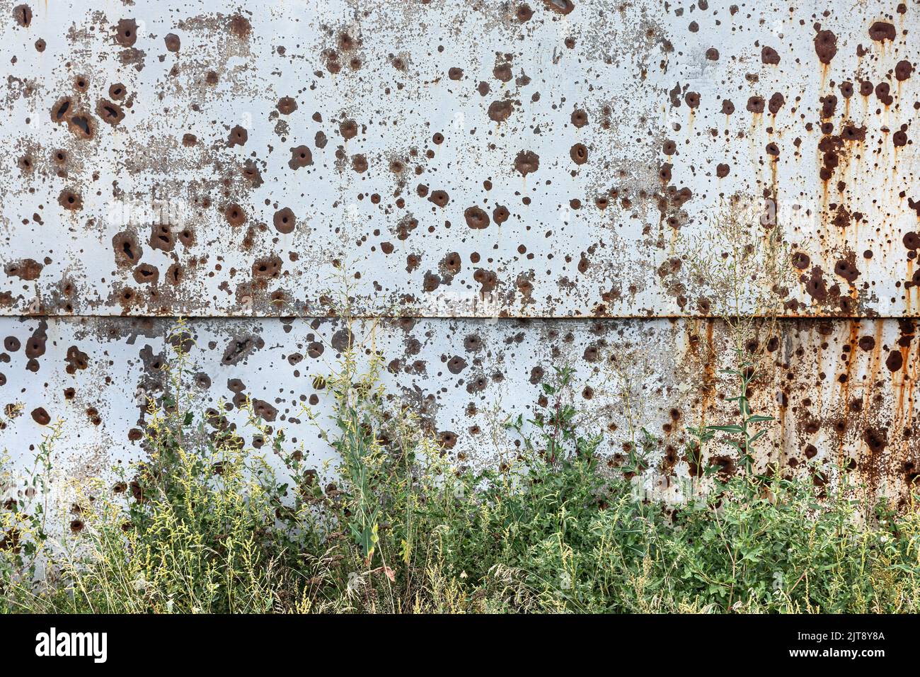 Concrete wall with numerous traces of fragments of exploding shells. On ...