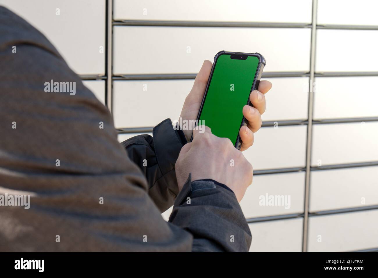 Female hand holding mobile phone with green screen chroma key next to ...
