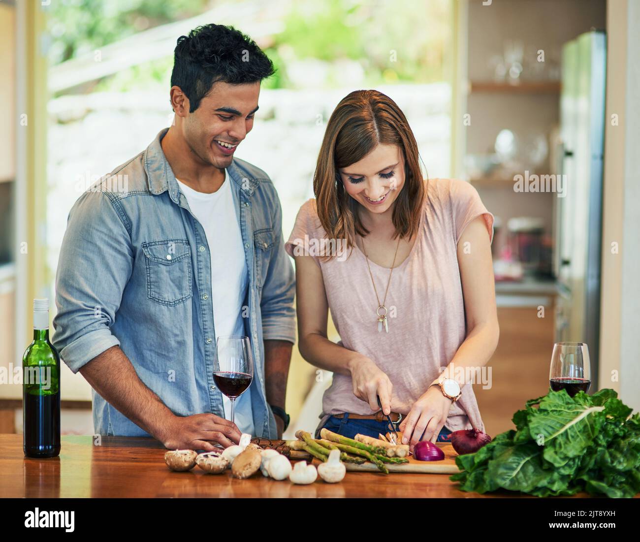 Shes making something healthy tonight. a young man watching his wife prepare dinner Stock Photo ...