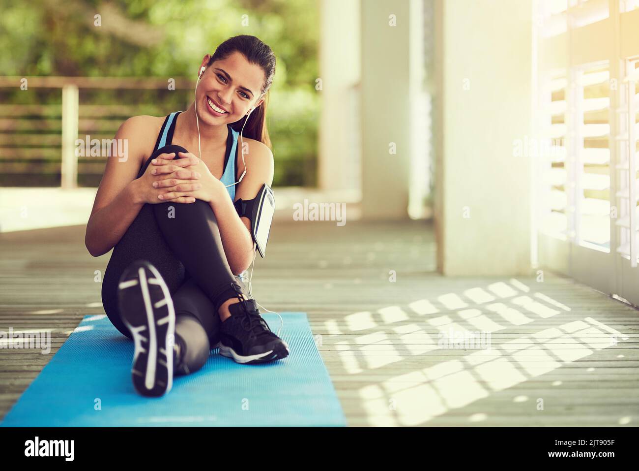 Im happiest on my yoga mat. Portrait of a sporty young woman sitting on ...