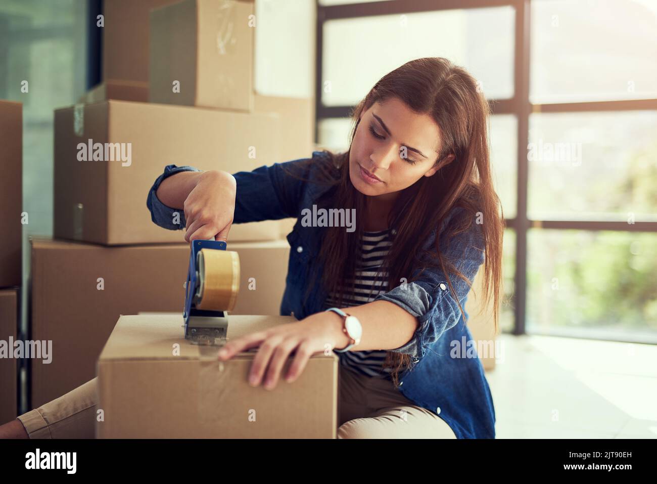 Securing the last of her things before the big move. a young woman ...