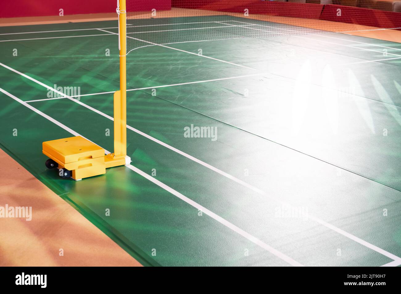 Yellow weighted pole badminton net base was placed on the side of a ...