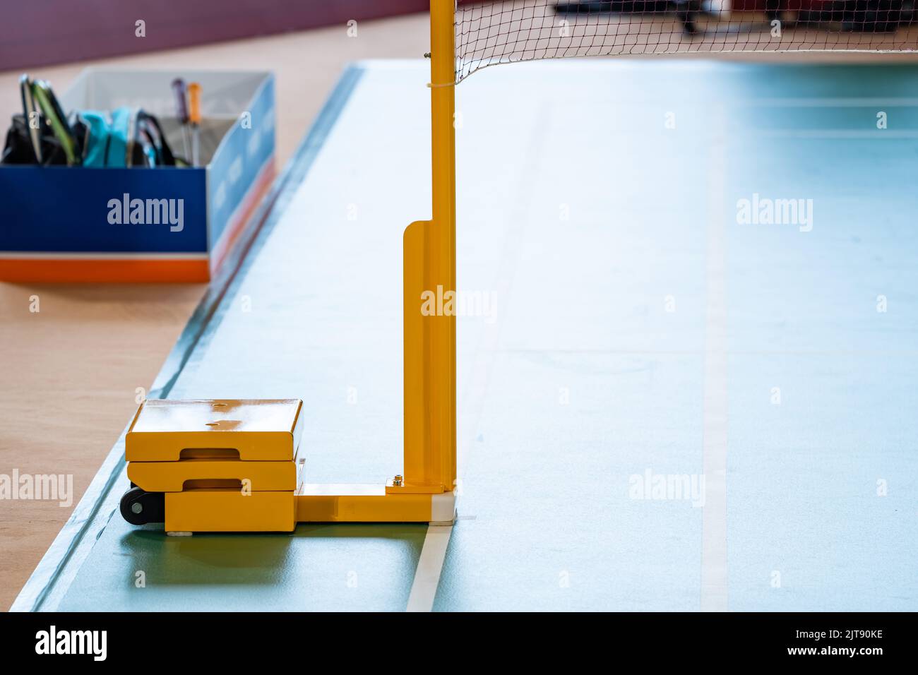 Yellow weighted pole badminton net base was placed on the side of a ...