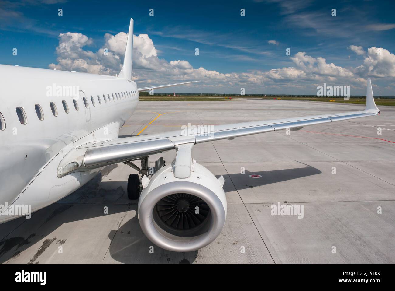 White passenger airliner on the airport apron. View of the wing and ...