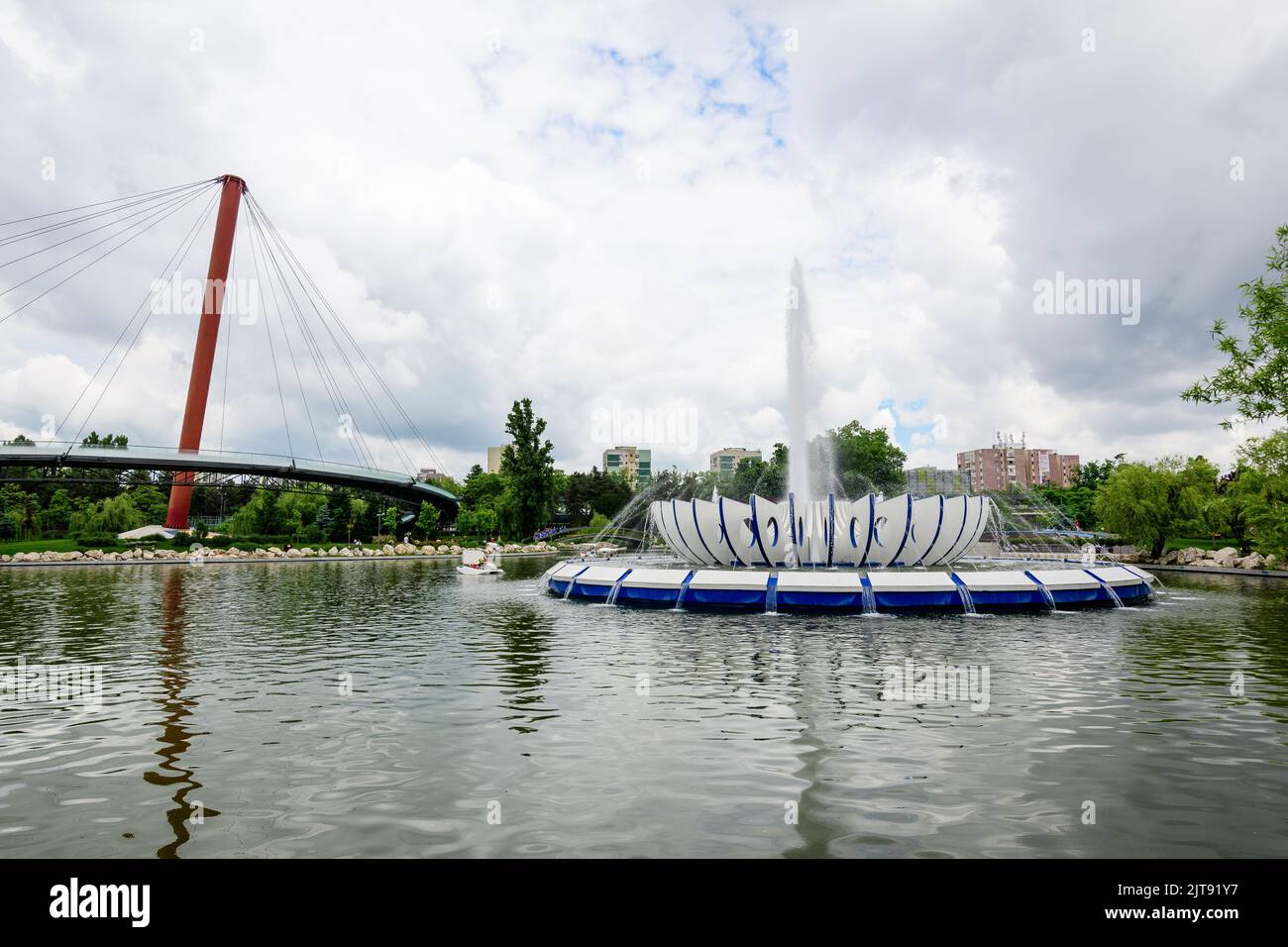 Landscape with the lake, decorative fountain and vivid green trees in ...