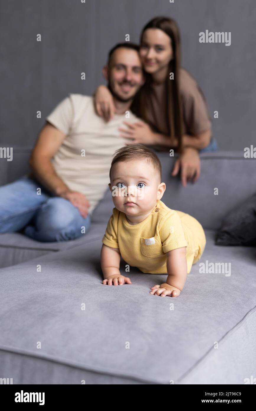 Parents and their son sit huddled in the living room and smiling Stock ...