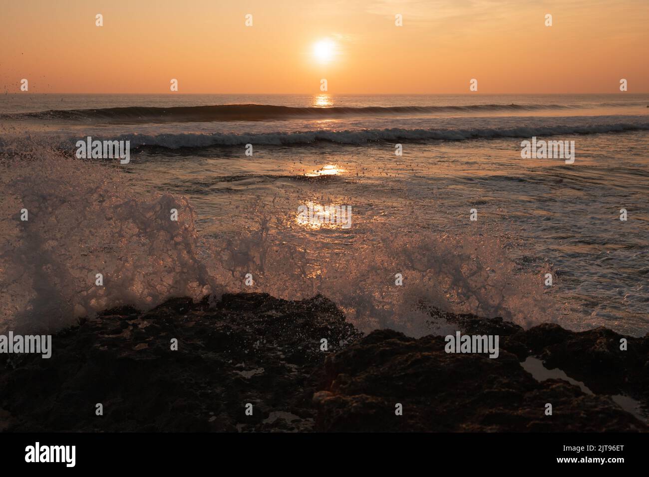 The waves crash on the rocks at scenic sunset over Atlantic ocean in ...