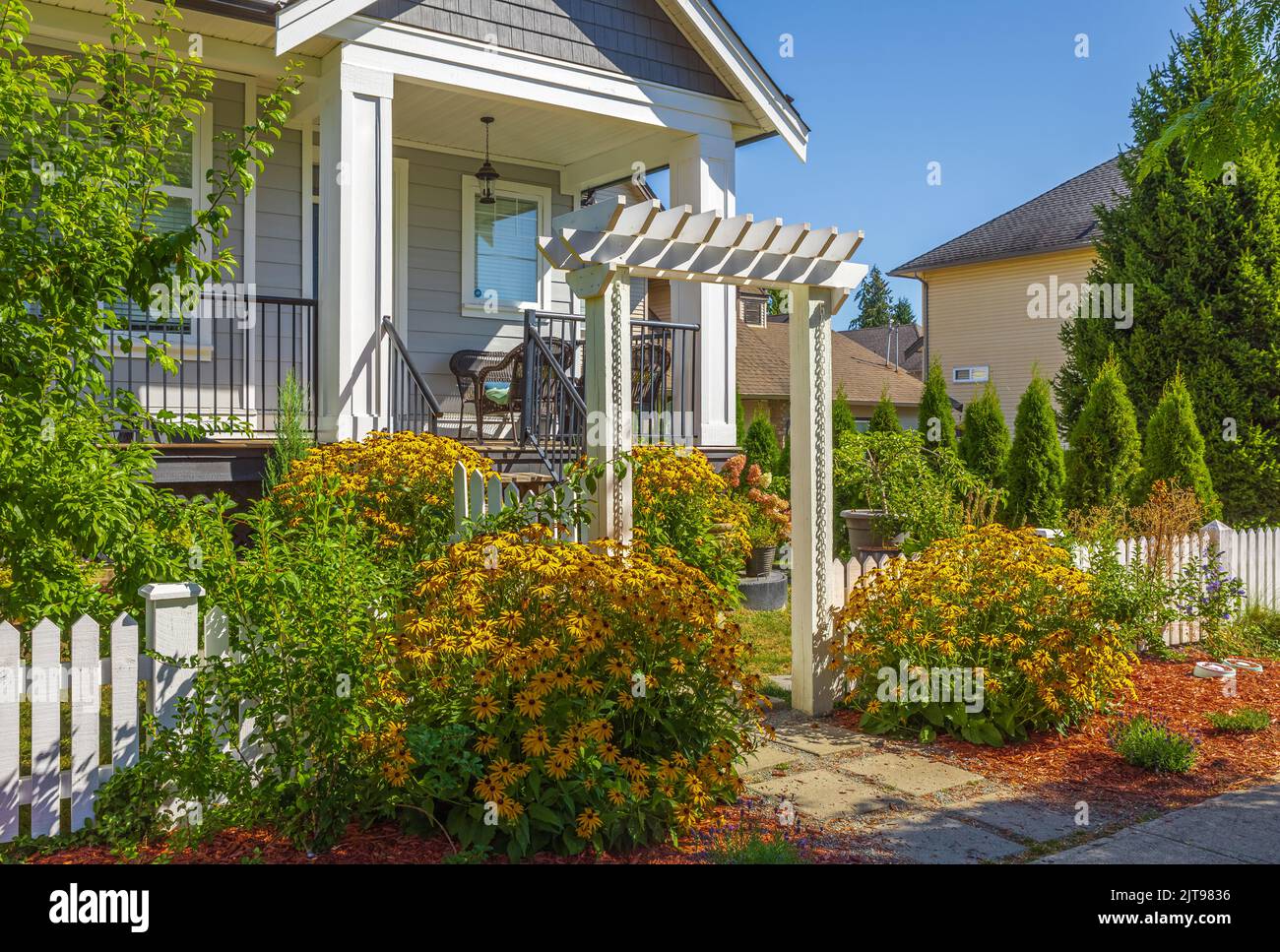 Entrance to a home through a beautiful garden with colorful flowers ...