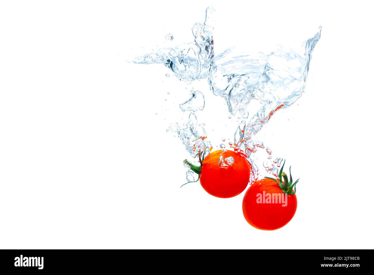 Cherry tomatoes falling underwater with splashes isolated on white ...