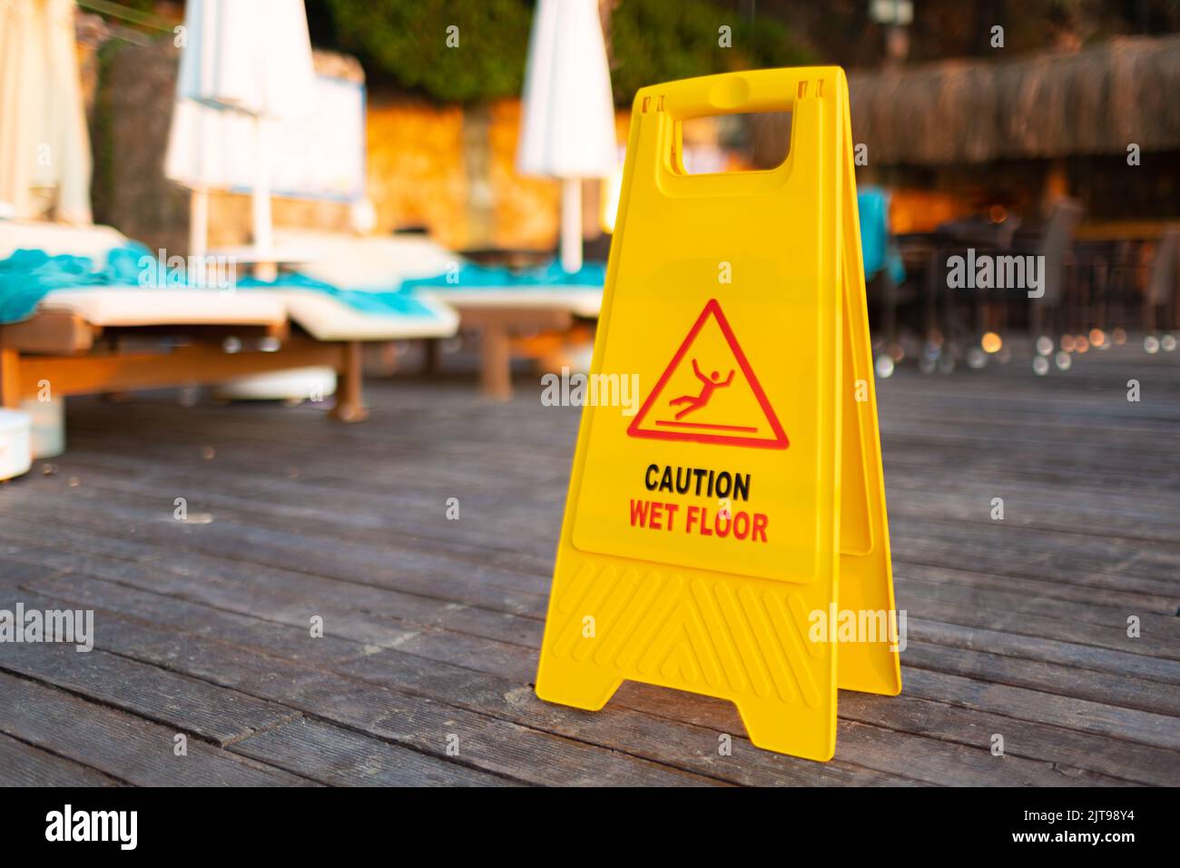 Wet floor caution sign on hotel terrace Stock Photo - Alamy