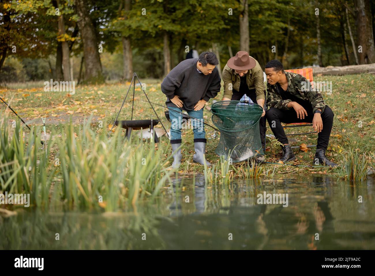Male friends look catch in fishing net at fishing Stock Photo - Alamy