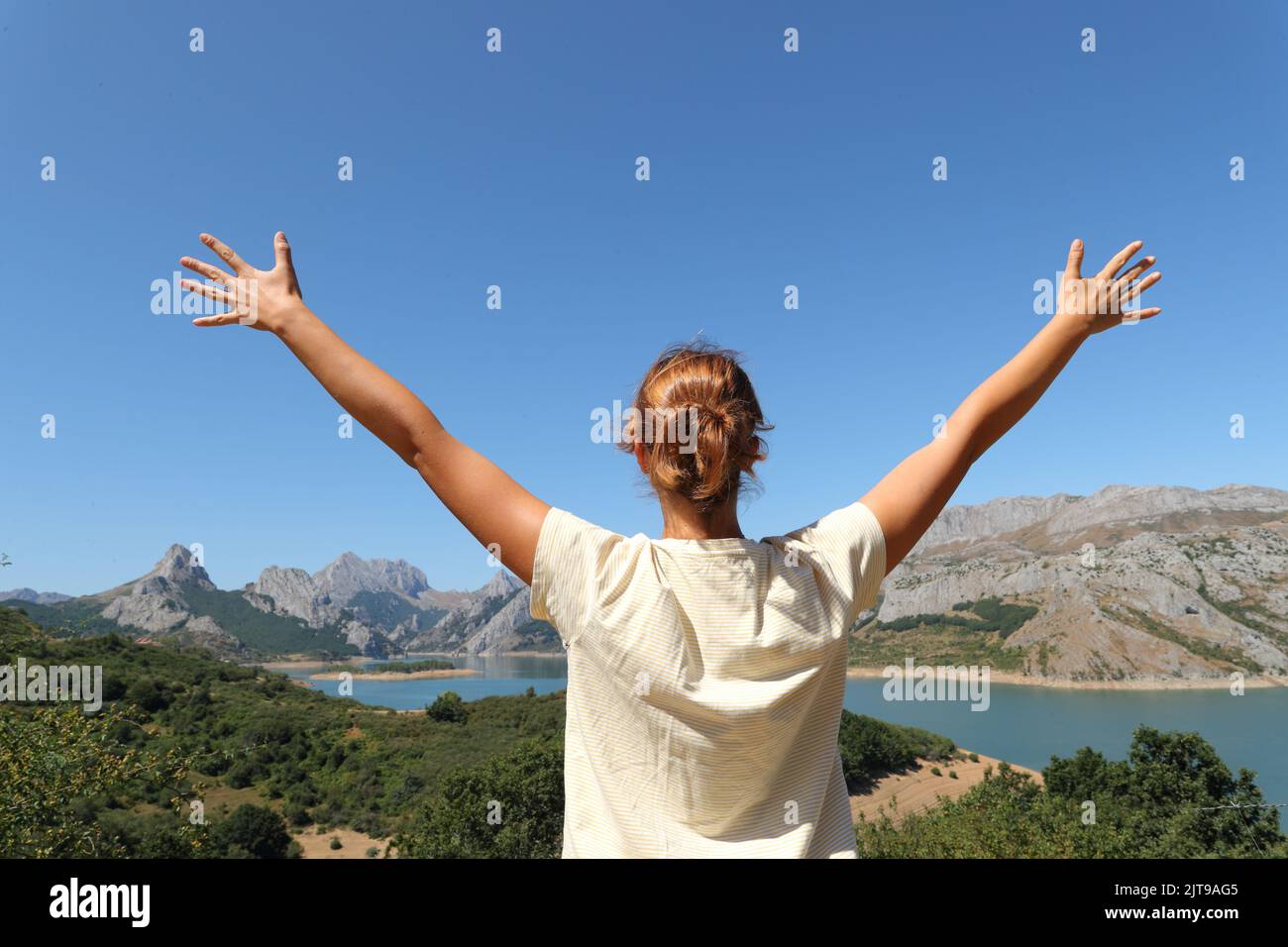 Back view portrait of a happy woman celebrating holiday in a mountain ...