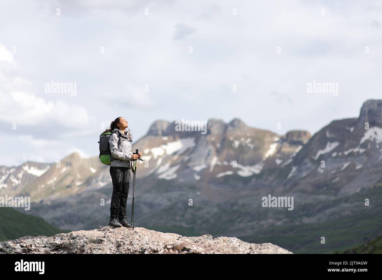 Full body portrait of a hiker breathing fresh air in a high mountain ...