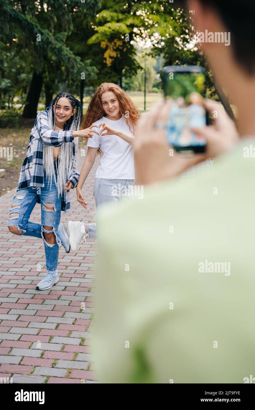 Rear view of a boy filming his girlfriends copying a trend from the ...