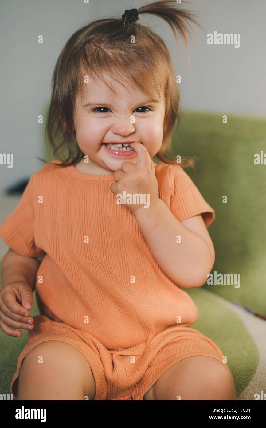 Front portrait of an adorable baby girl smiling while touching her milk ...