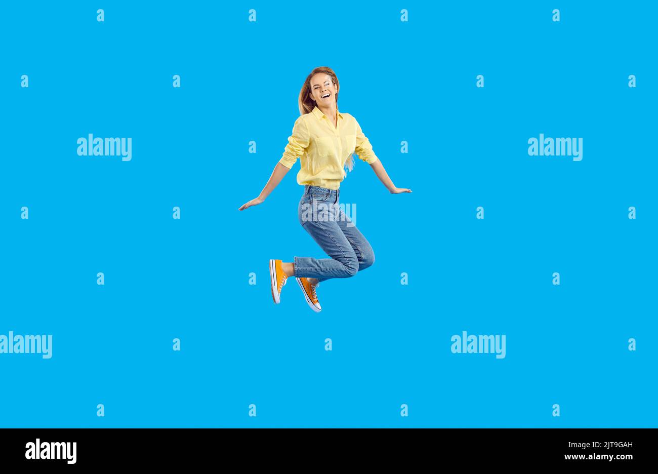 Cheerful funny teen girl having fun bouncing isolated on light blue ...