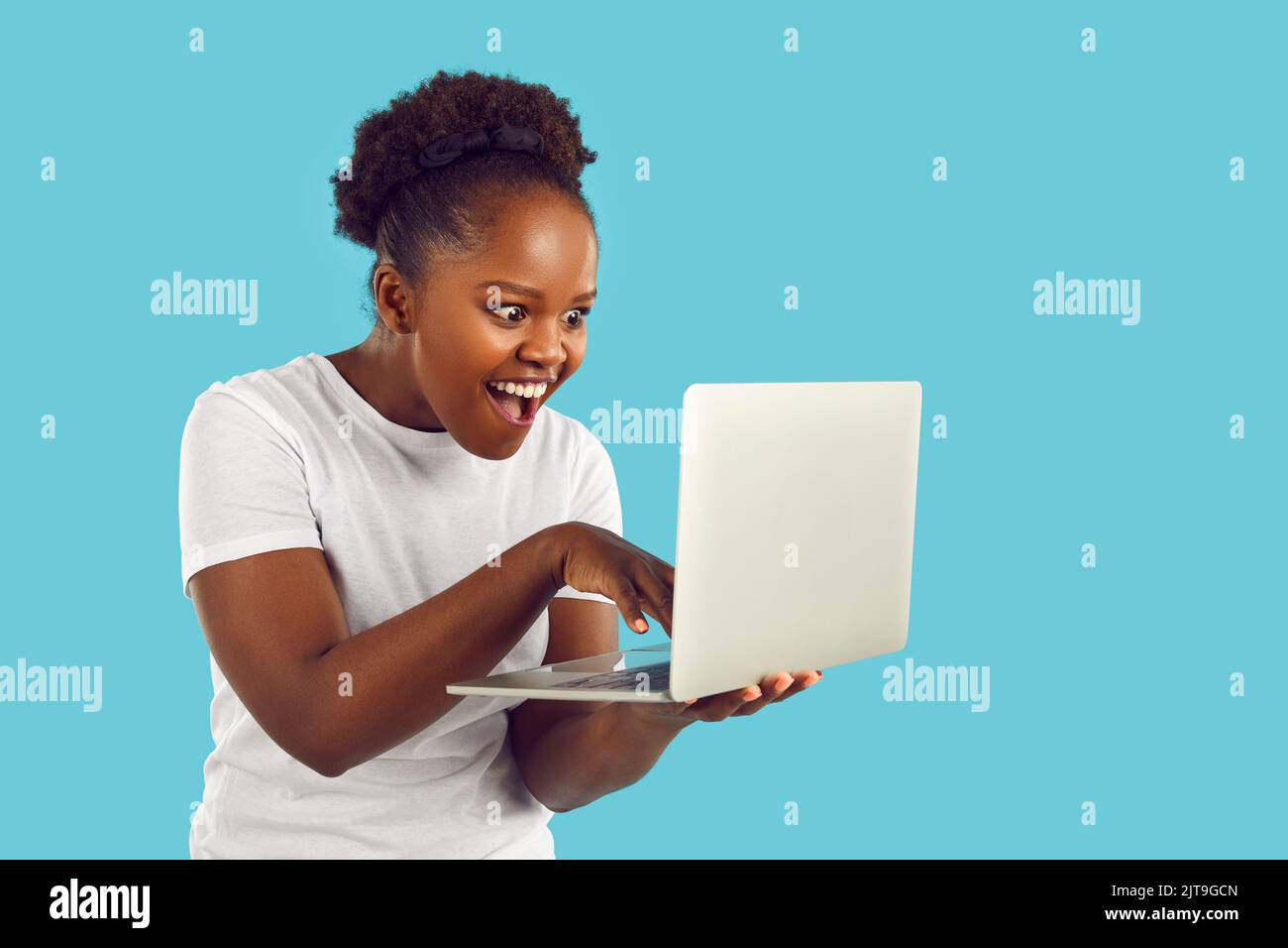 Funny woman with crazy facial expression looks at laptop screen on ...