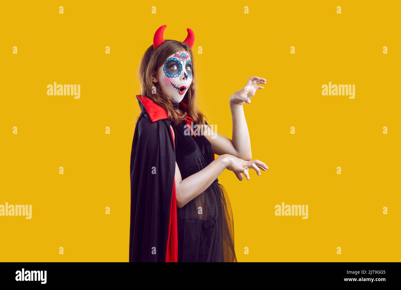 Amazed woman dressed as crazy devil with terrible makeup shows to copy ...
