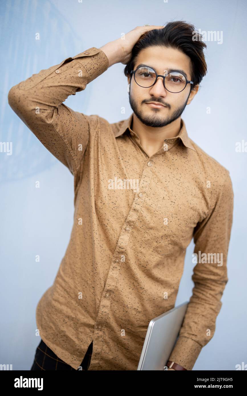 Young indian man with laptop looking at camera Stock Photo - Alamy