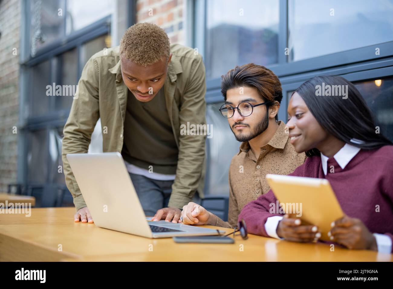 Multiracial students watch some on laptop outdoors Stock Photo - Alamy