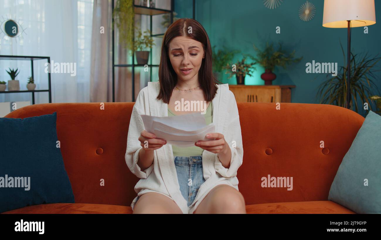Stressed girl at home room looking at unpaid bank debt bills, doing ...