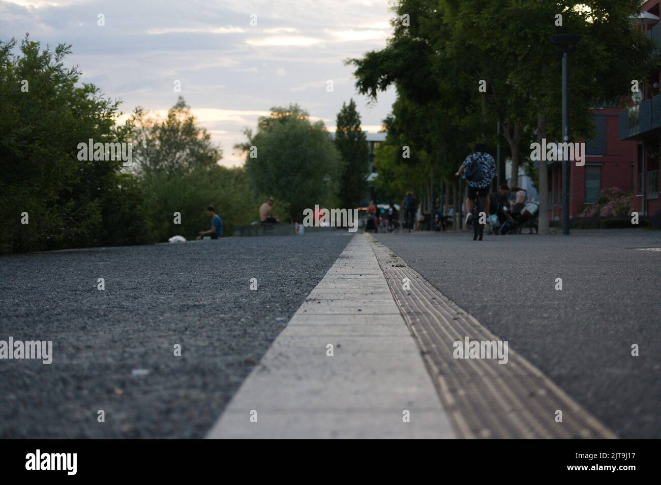 A low-angle shot of a street line with background of people and trees ...