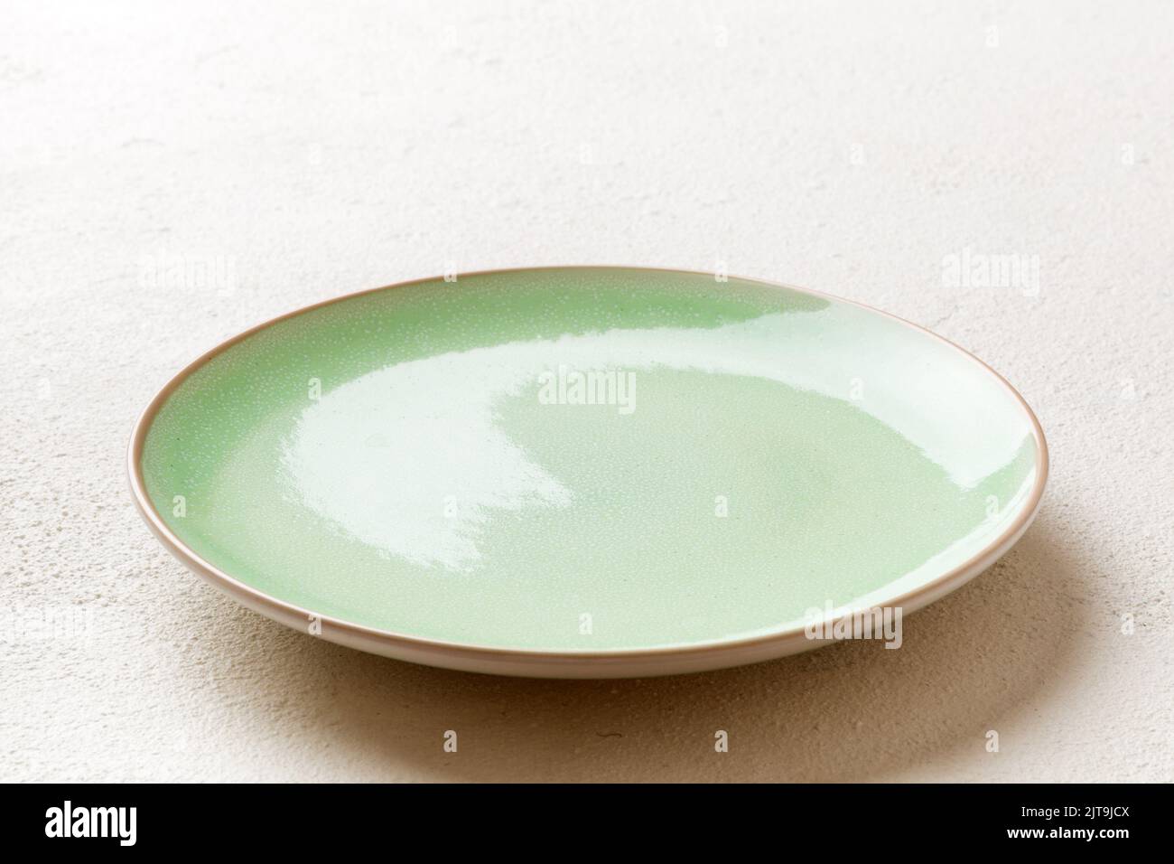Perspective view of empty green plate on cement background. Empty space ...