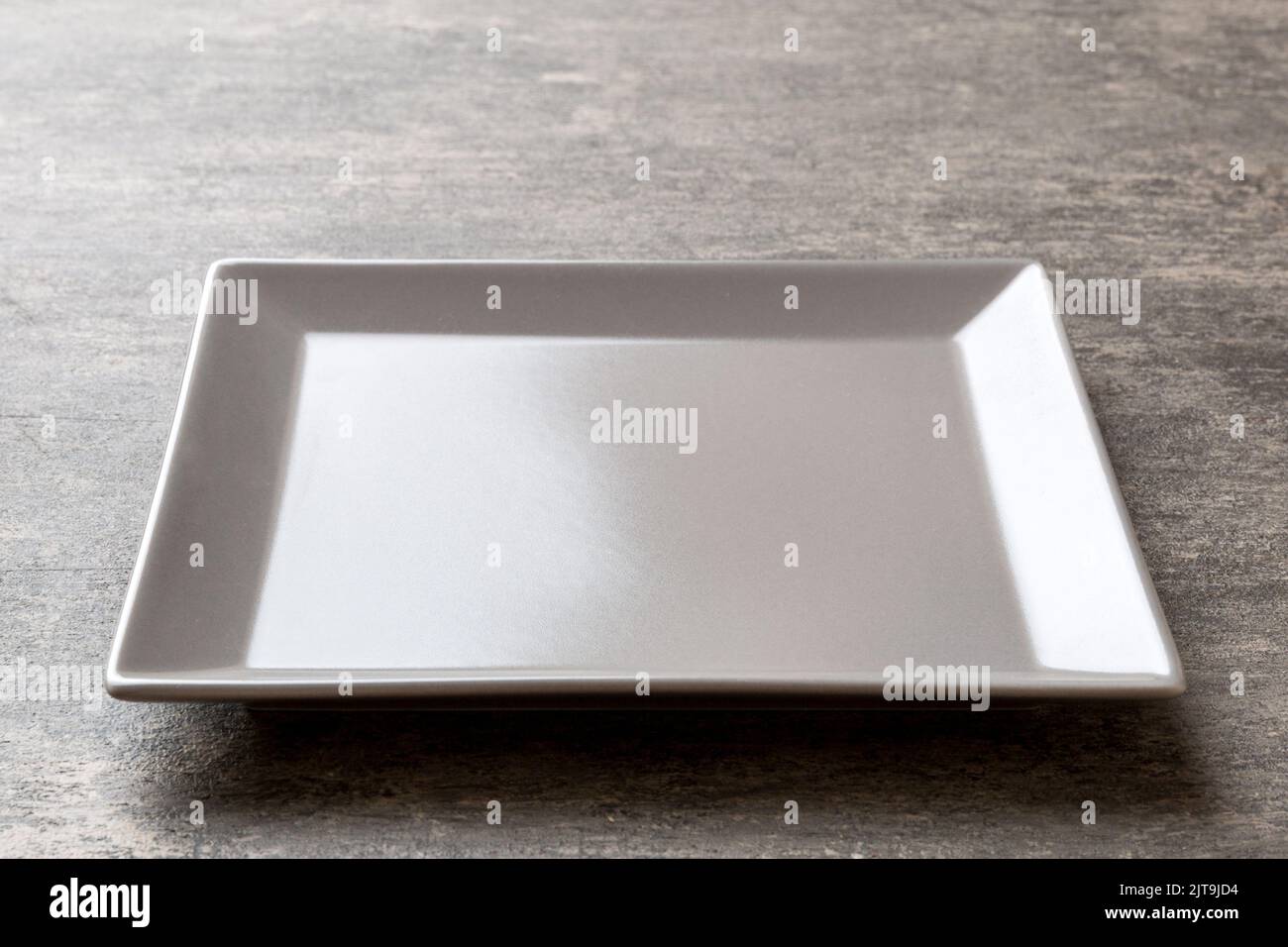 Perspective view of empty square plate on cement background. Empty ...