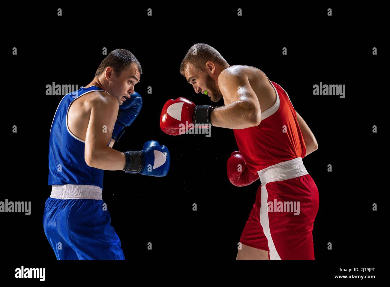 Young men, professional boxers in red and blue sports uniform boxing ...