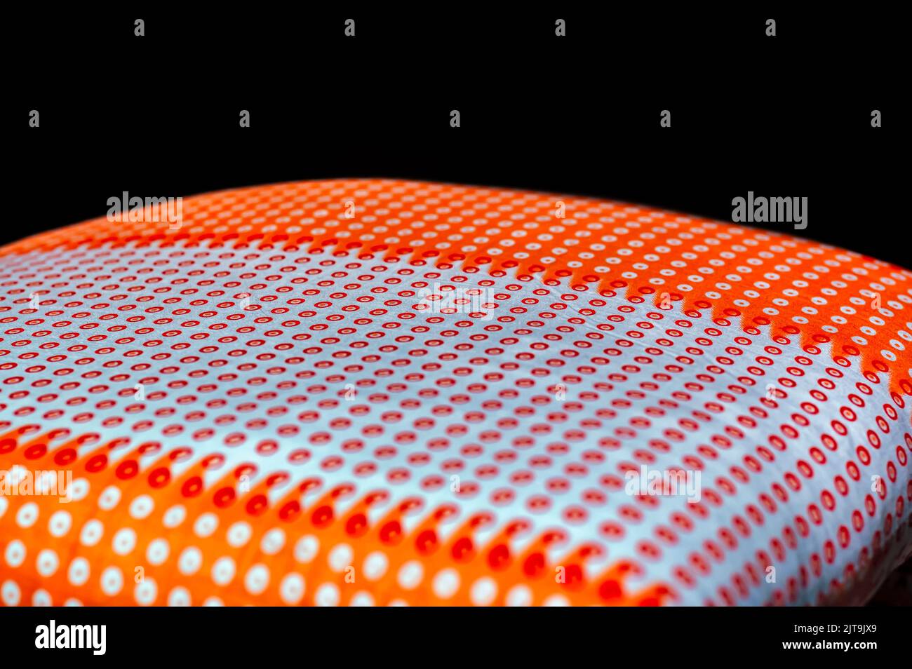 A polka dotted sheet of cloth isolated against a black background Stock ...
