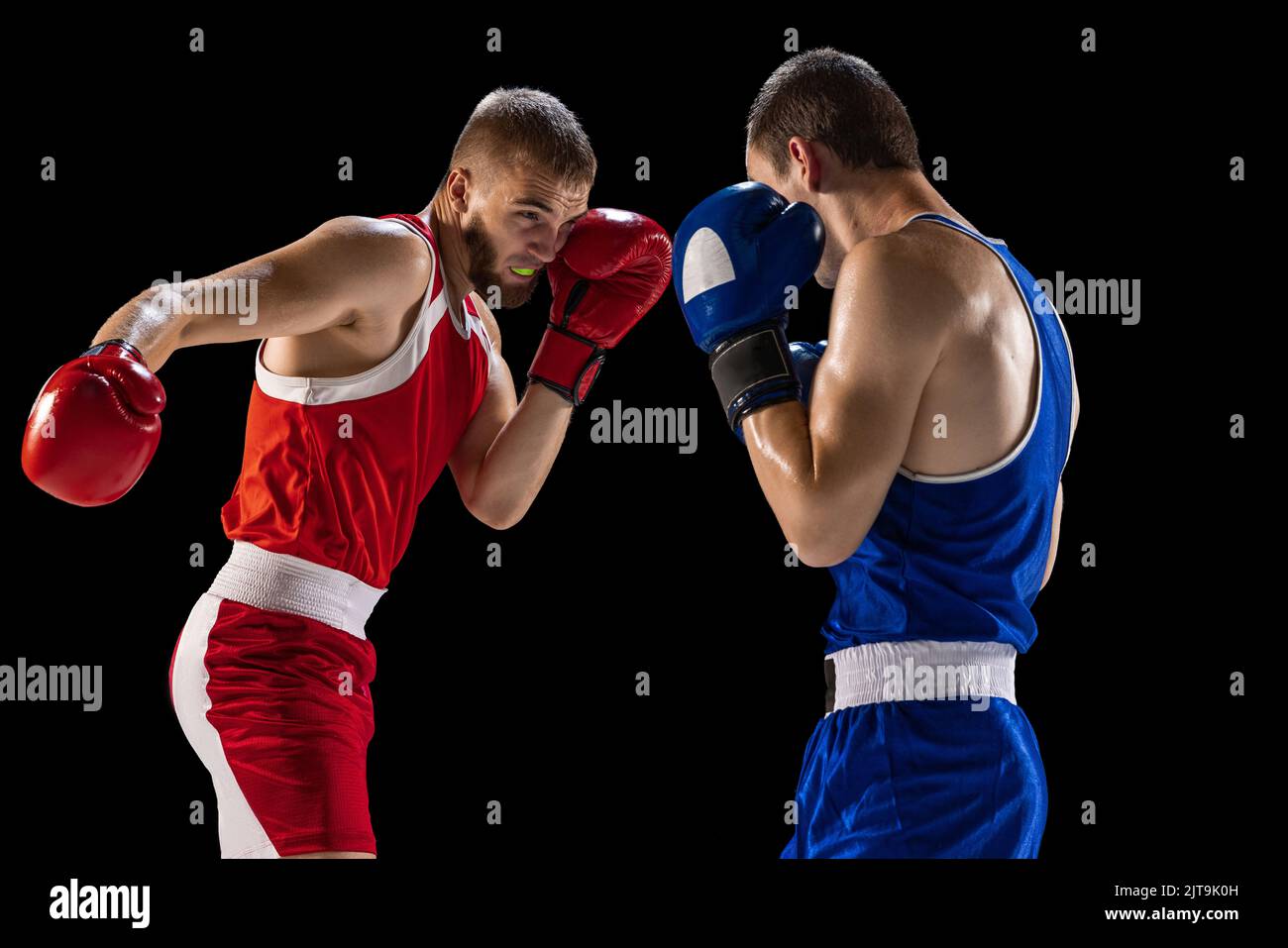 Young men, professional boxers in red and blue sports uniform boxing ...