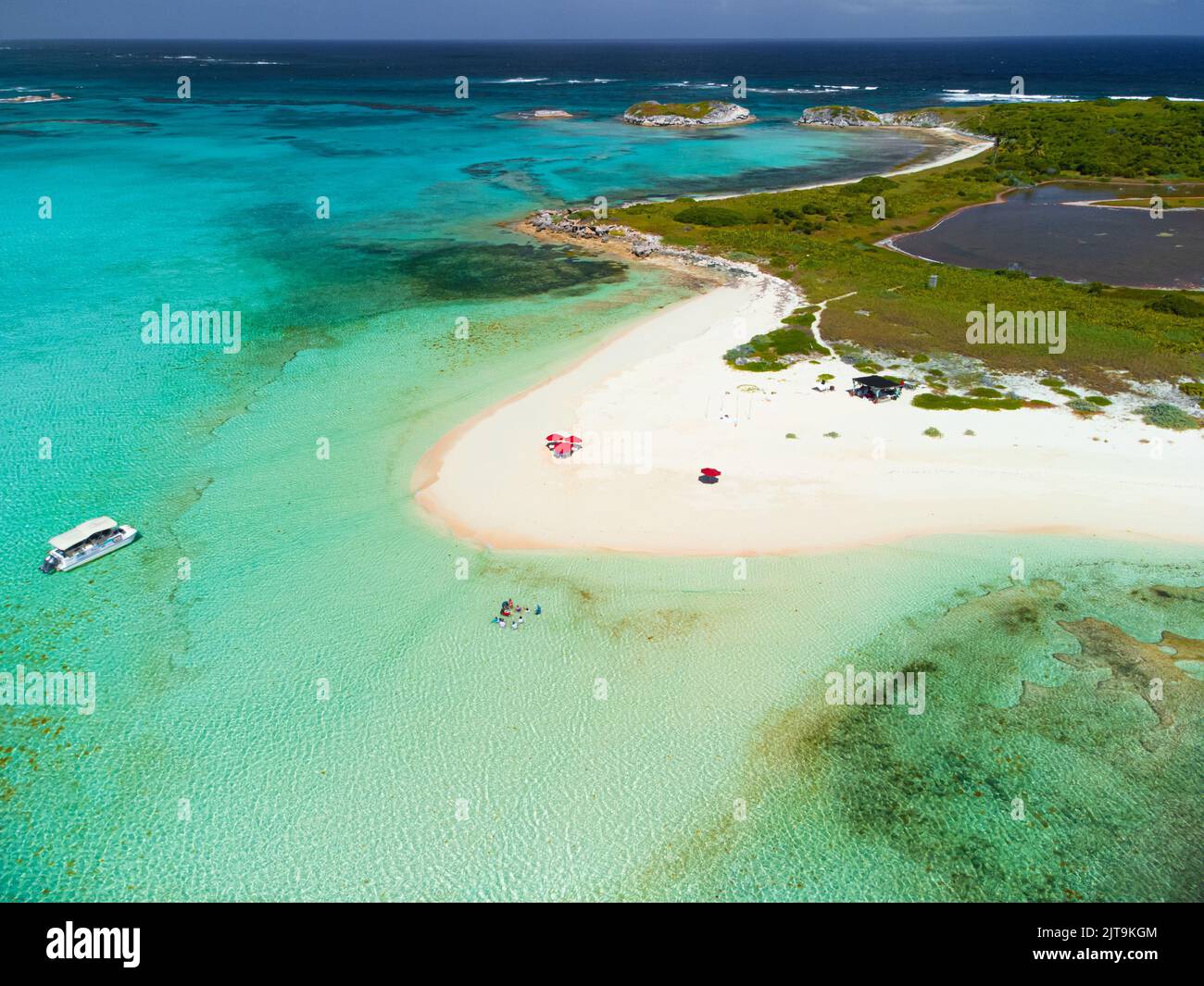 An aerial view of a boat in turquoise sea against a beautiful beach in ...
