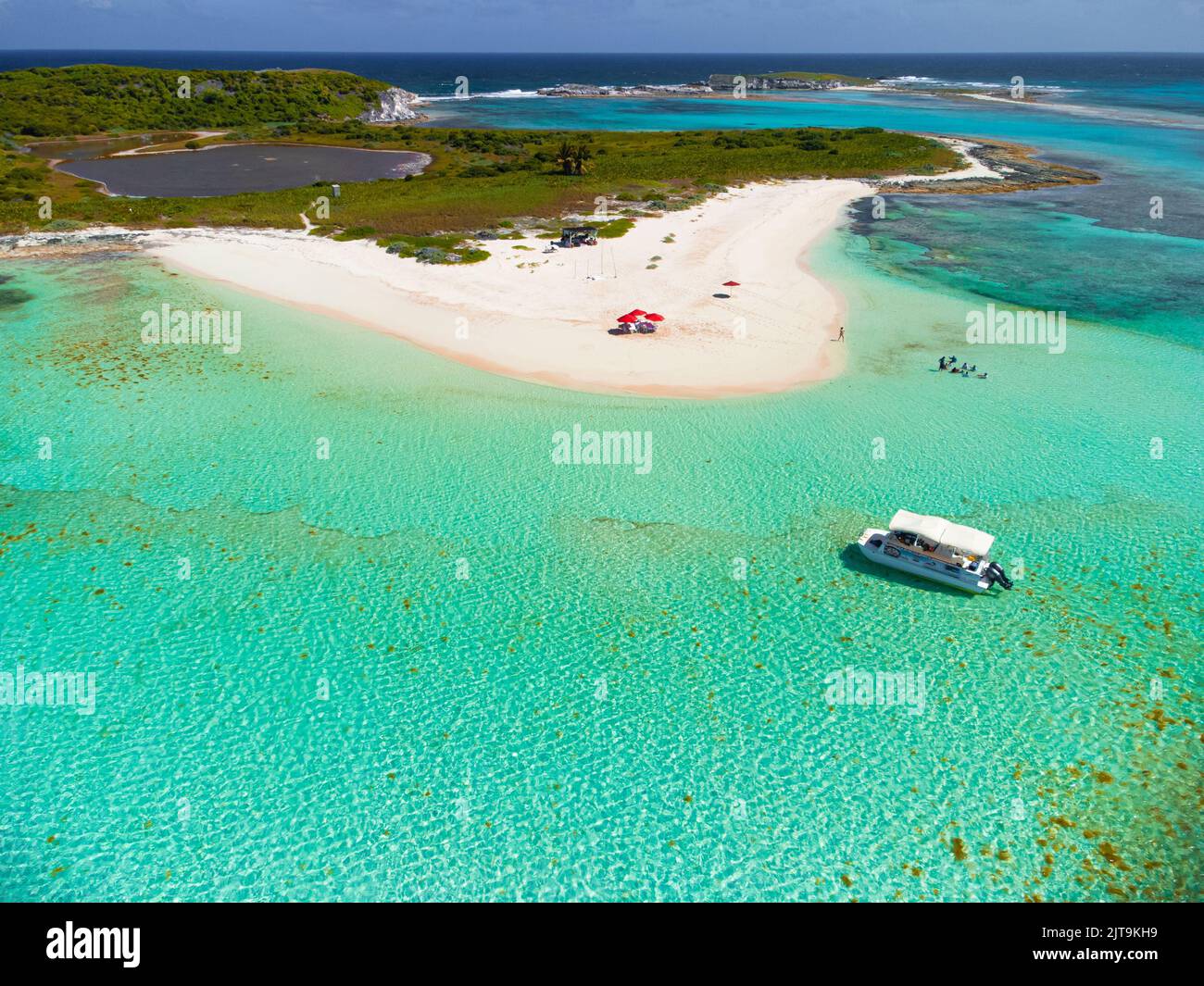 An aerial view of a boat in turquoise sea against a beautiful beach in ...